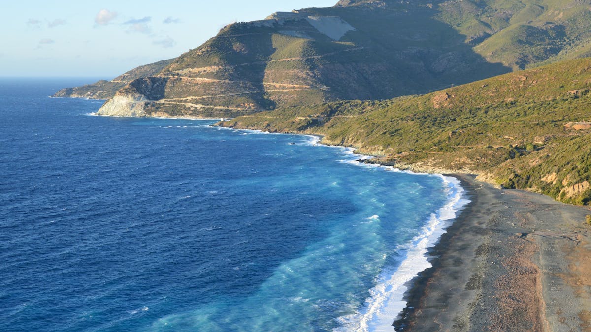Coastal cliffs and a sandy beach along the Mediterranean