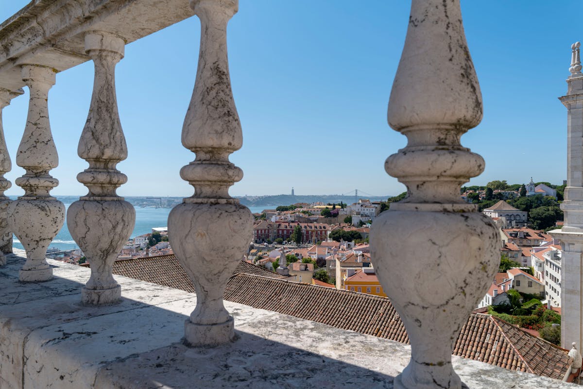View of Lisbon old town and Tagus River through a stone arch