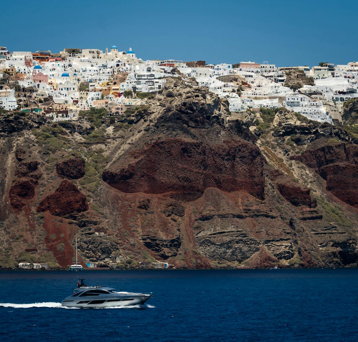 Yacht cruising near Santorini cliffs