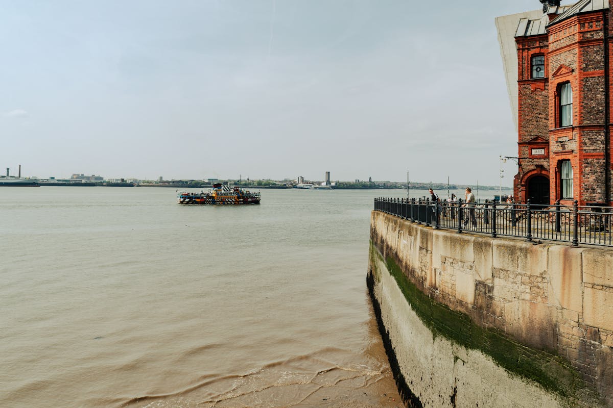 Liverpool harbor view with a Mersey ferry and red brick Albert Dock buildings