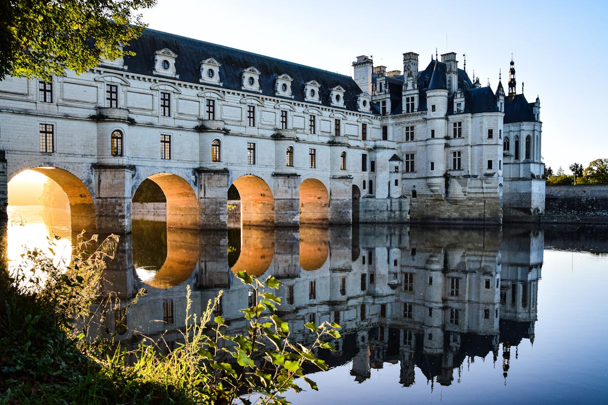Chenonceau Castle spanning the Cher River with lush surroundings