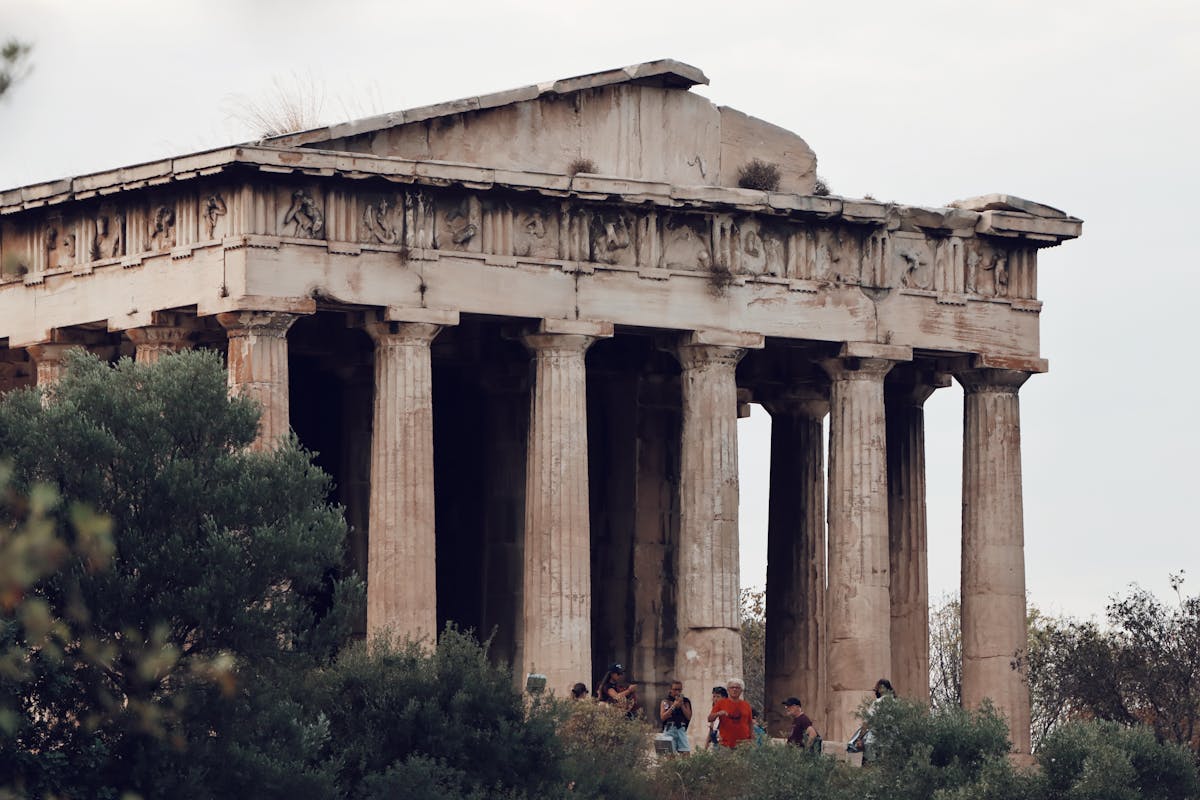 Ancient Temple of Hephaestus in Athens surrounded by cypress trees