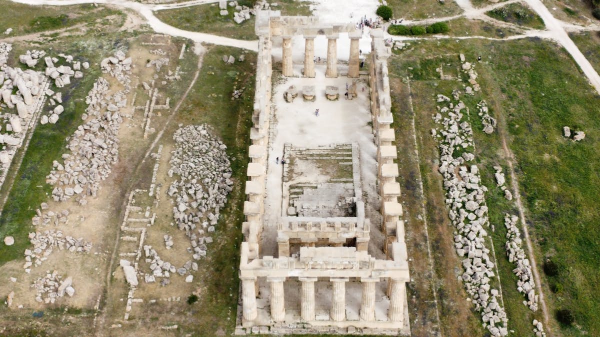 Aerial view of ancient Greek temple ruins with standing columns