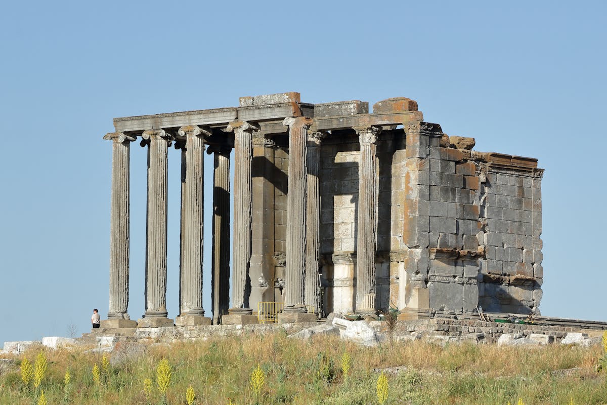 Ancient Greek temple ruins with standing columns under clear blue sky