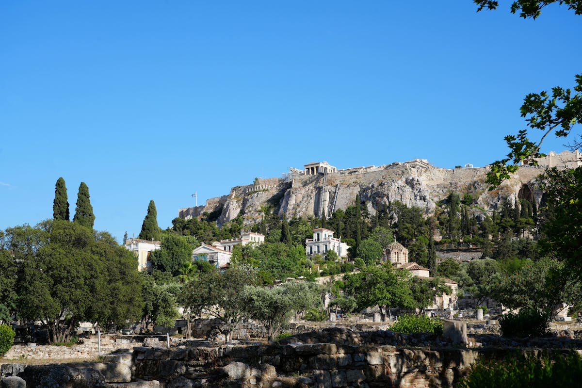 The Acropolis of Athens surrounded by green trees on a clear day
