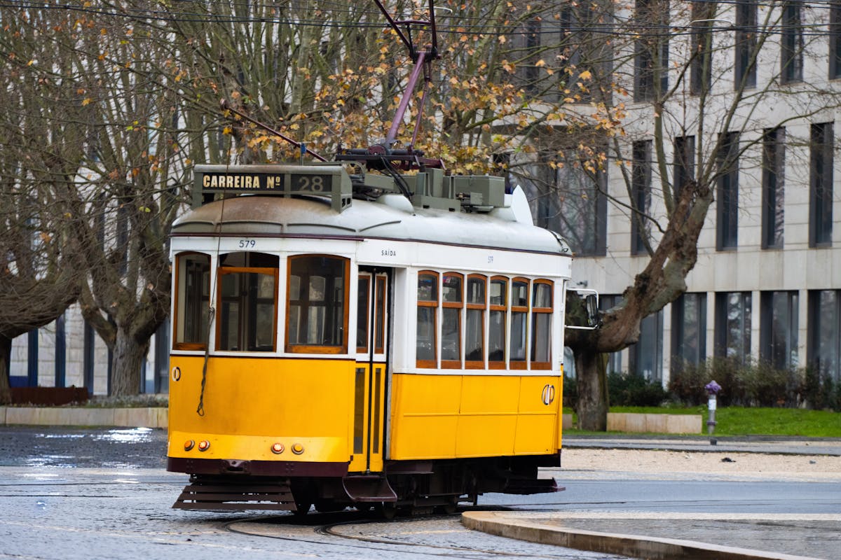 Classic yellow Tram 28 navigating through narrow Lisbon streets