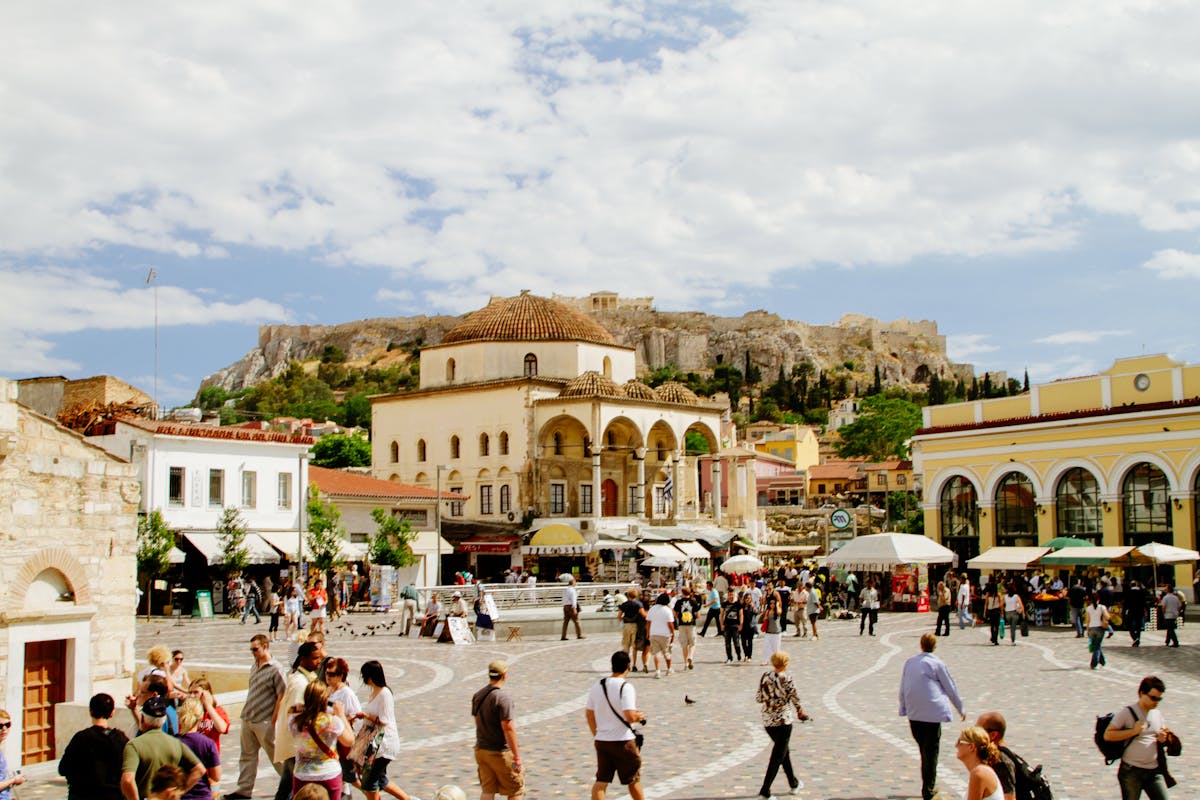 Busy Monastiraki Square in Athens during the day with Acropolis behind