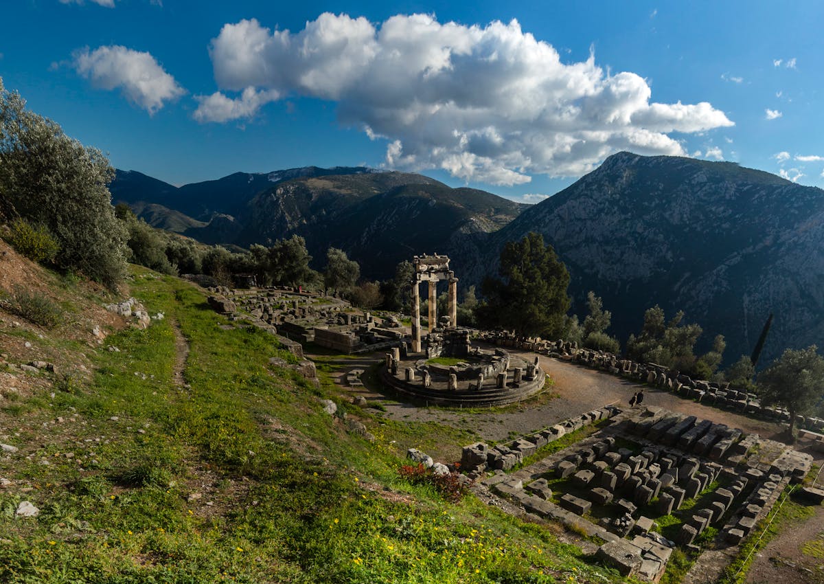 Ancient Greek ruins at Delphi set against a mountainous landscape
