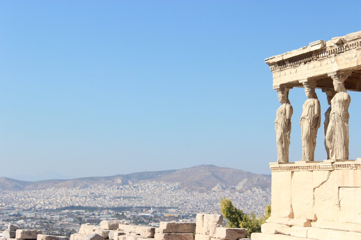 Caryatid porch of the Erechtheion temple with the Athens cityscape behind