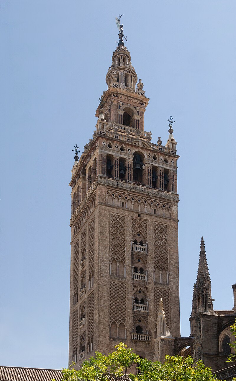The Giralda tower seen through orange trees in the Patio de los Naranjos courtyard