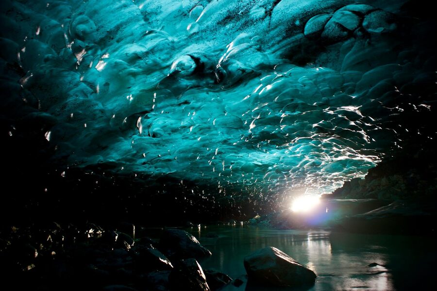 A striking view of a natural blue ice cave in Iceland, showcasing icy textures and sunlight refle