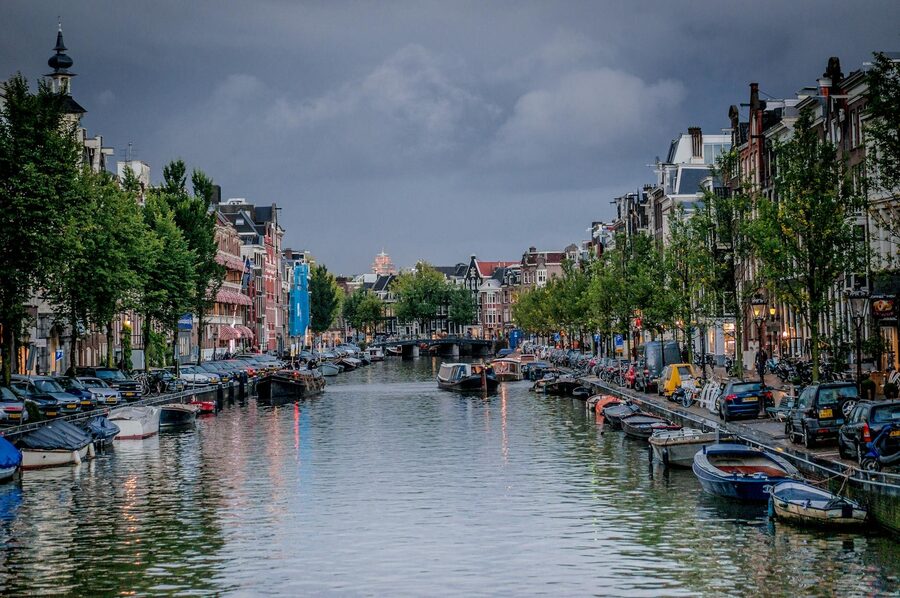 Picturesque view of an Amsterdam canal with boats and traditional architecture