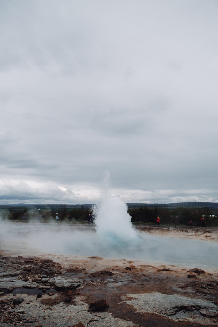 Group of travelers watching a geyser eruption in Iceland