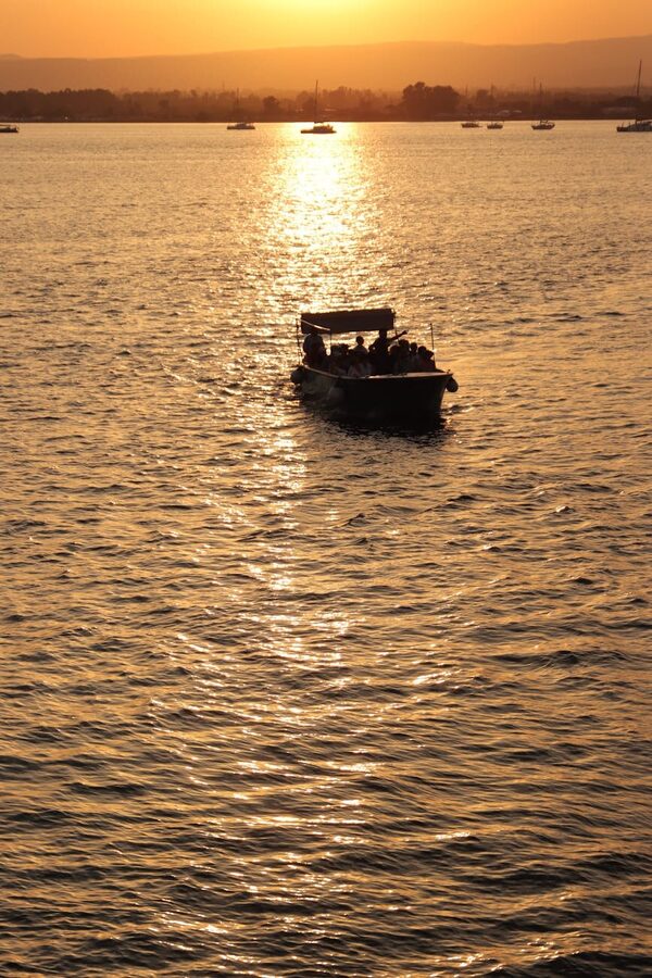 Scenic view of a boat on the Bosphorus at sunset with bridge silhouette