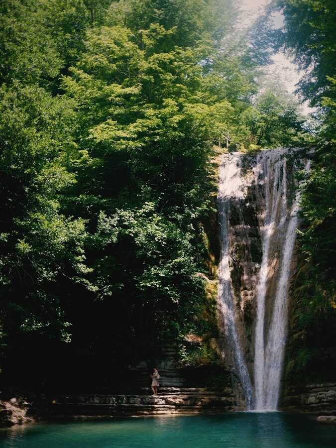 Boat cruising on lake with autumn foliage reflections at Plitvice Lakes Croatia