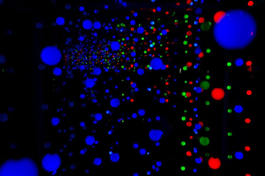 Abstract display of vivid blue red and green light spheres in a dark space