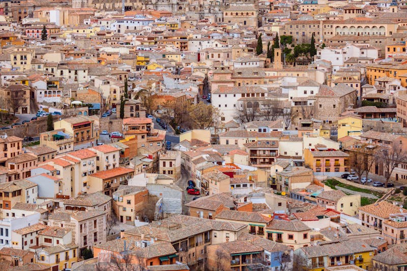 Drone shot showing the dense medieval layout of Toledo old town with terracotta rooftops