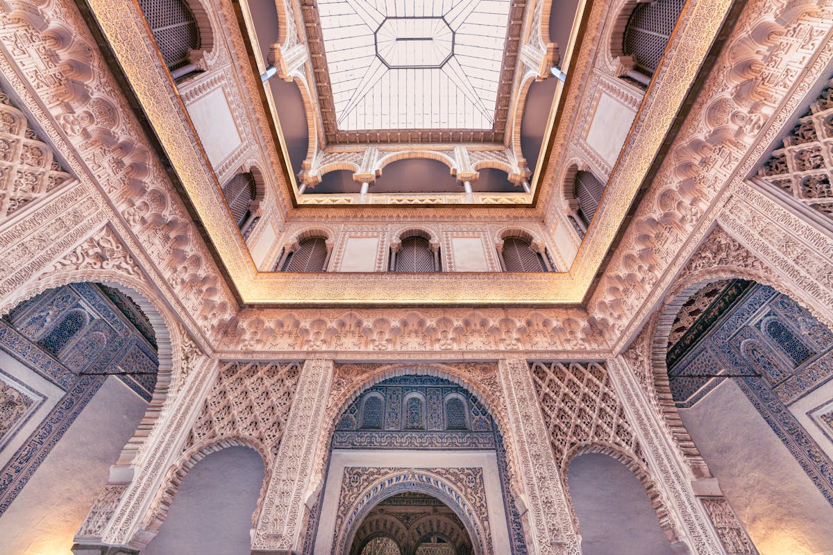 Intricate Moorish architectural details and arches inside the Alcazar of Seville
