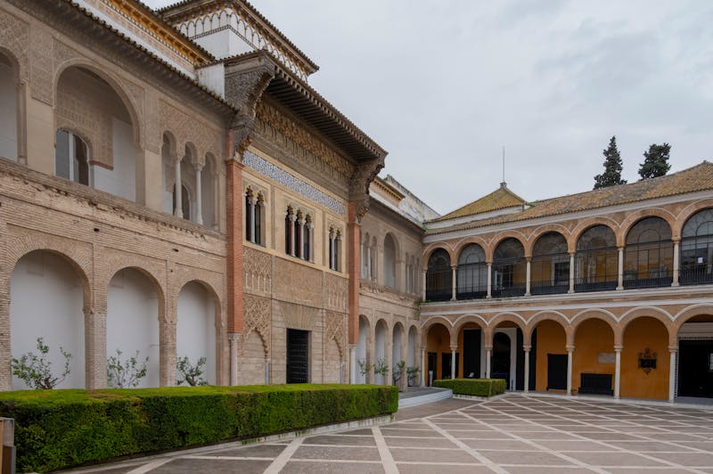 Beautiful courtyard view of the Alcazar of Seville showcasing Moorish arches and reflecting pool