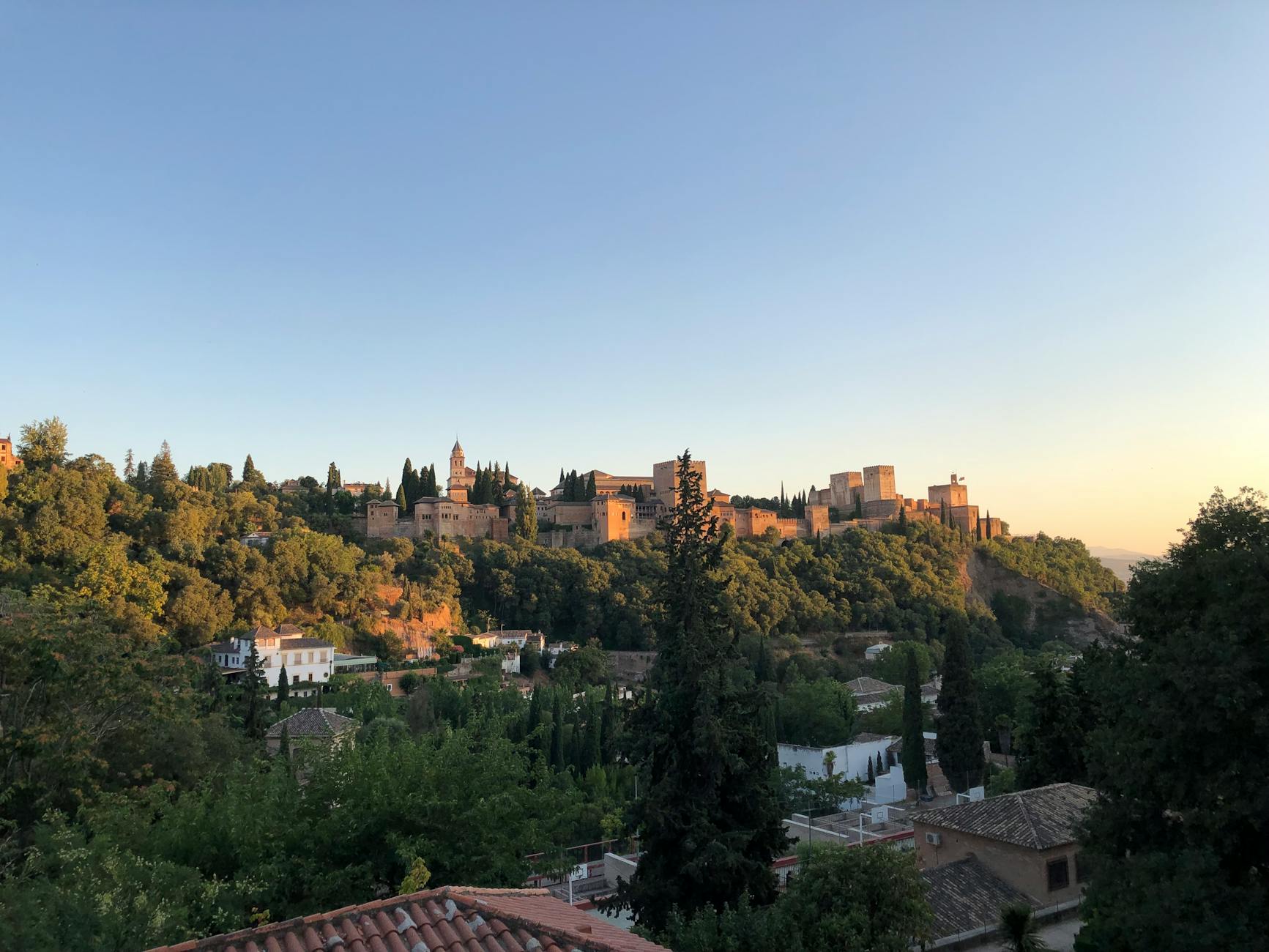 Alhambra palace surrounded by greenery at sunset