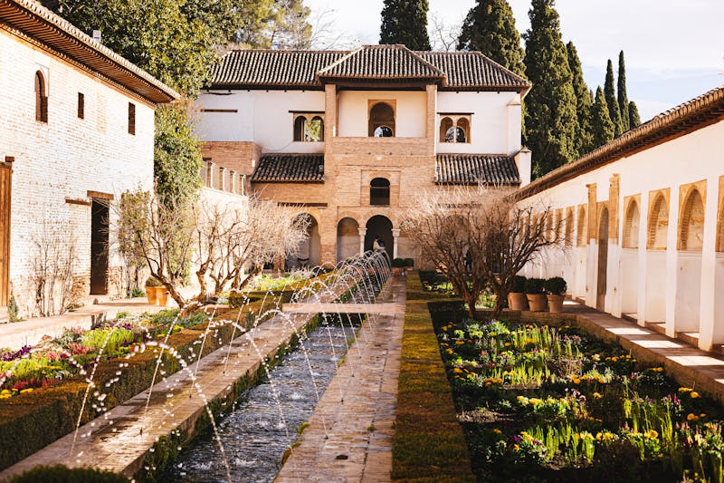 Courtyard garden with hedges and towers at the Alhambra Palace in Granada