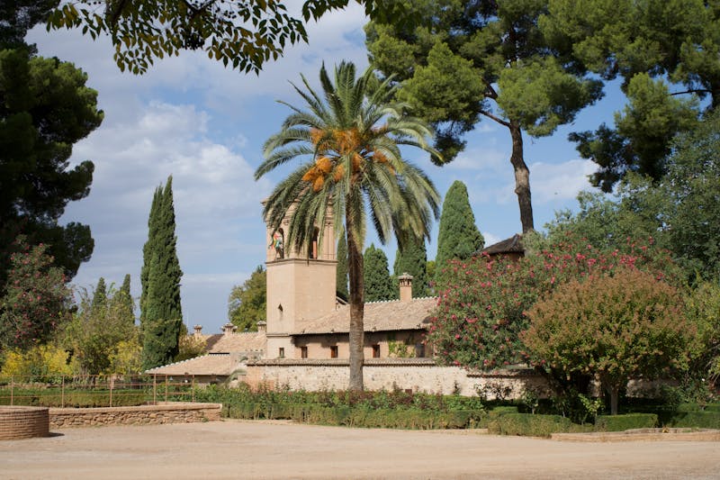 Historic buildings surrounded by palm trees and gardens in Granada Spain