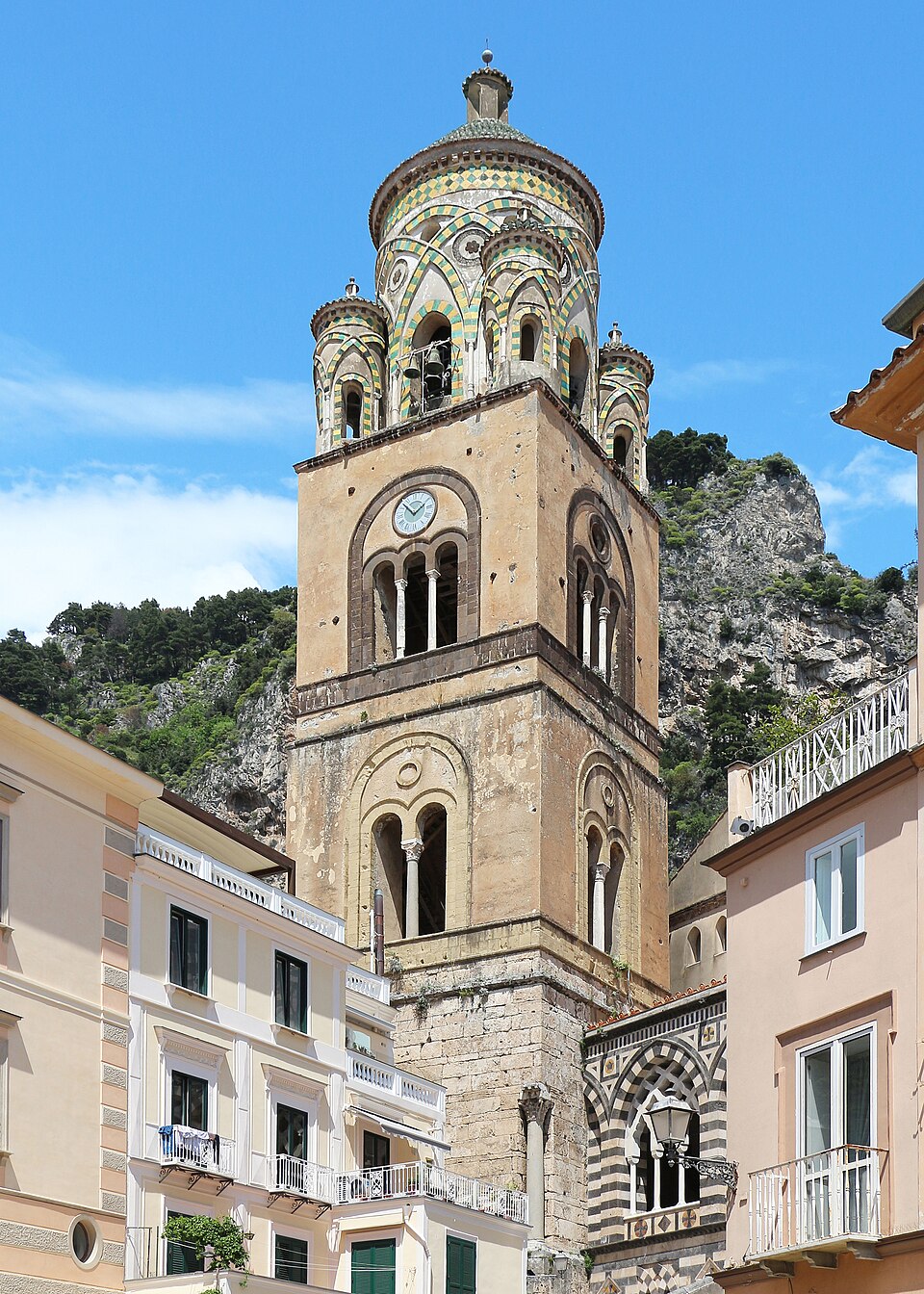 The ornate striped facade and bell tower of the Duomo di Amalfi Cathedral