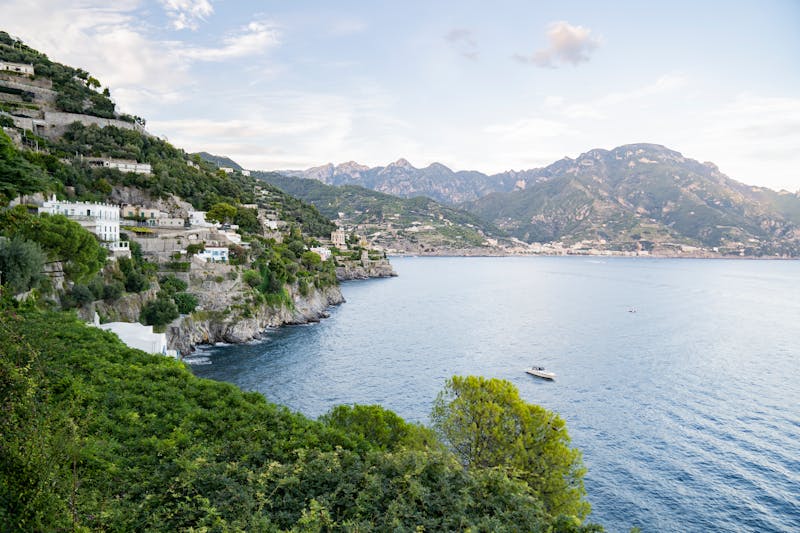 Panoramic view of the Amalfi coastline with lush green cliffs and calm blue sea