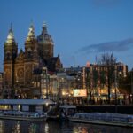 Evening view of the Basilica of St Nicholas by the canal in Amsterdam