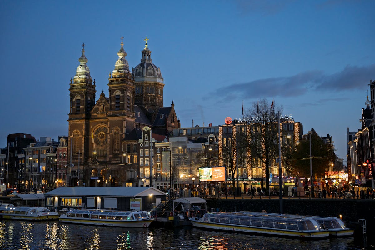 Evening view of the Basilica of St Nicholas by the canal in Amsterdam