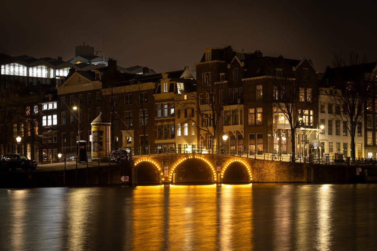 Scenic view of Amsterdam canal bridge and traditional architecture at night