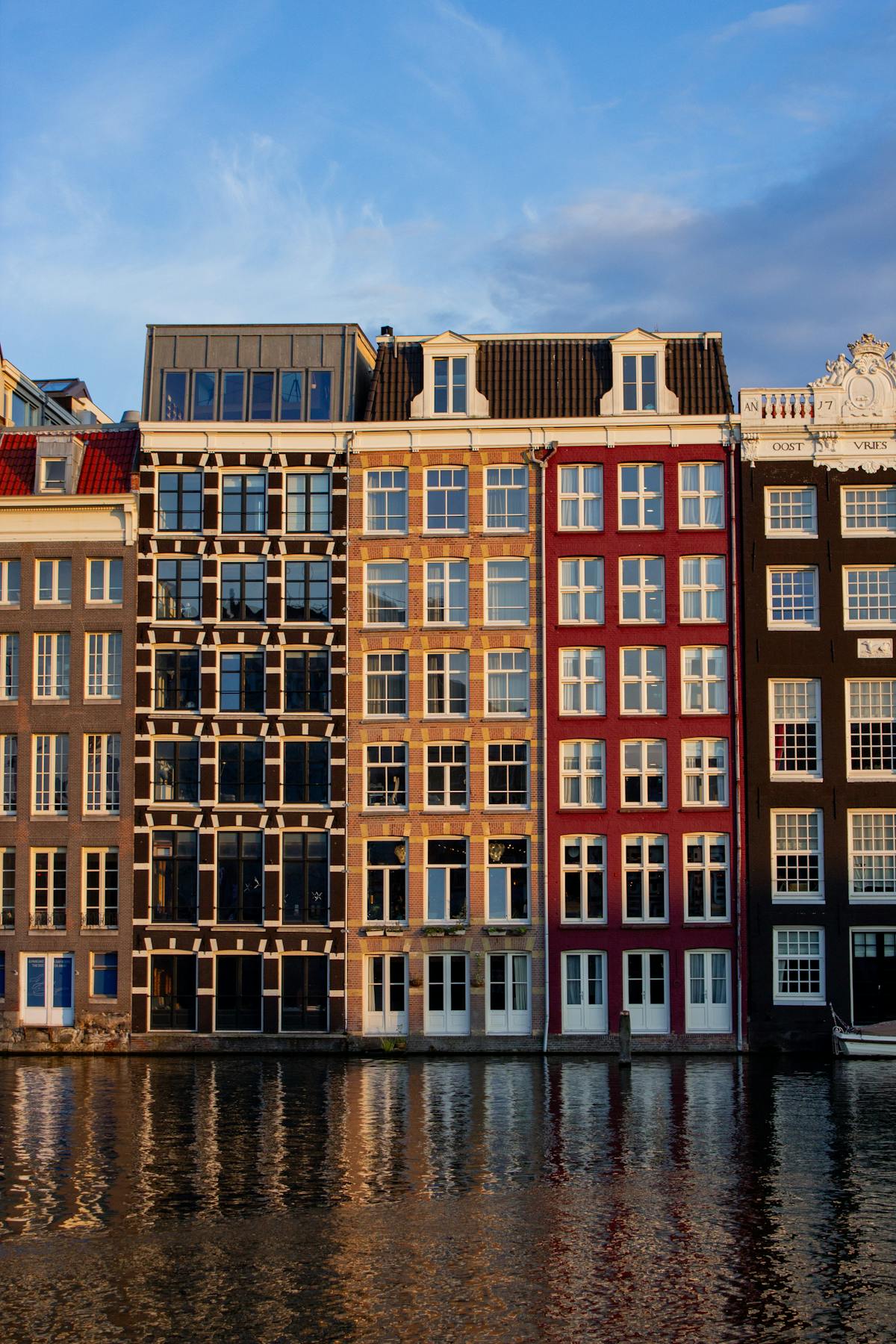 Amsterdam canal houses reflected in the water during a golden sunset