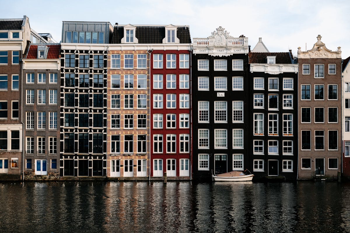 Row of colorful canal houses by the water in Amsterdam Netherlands