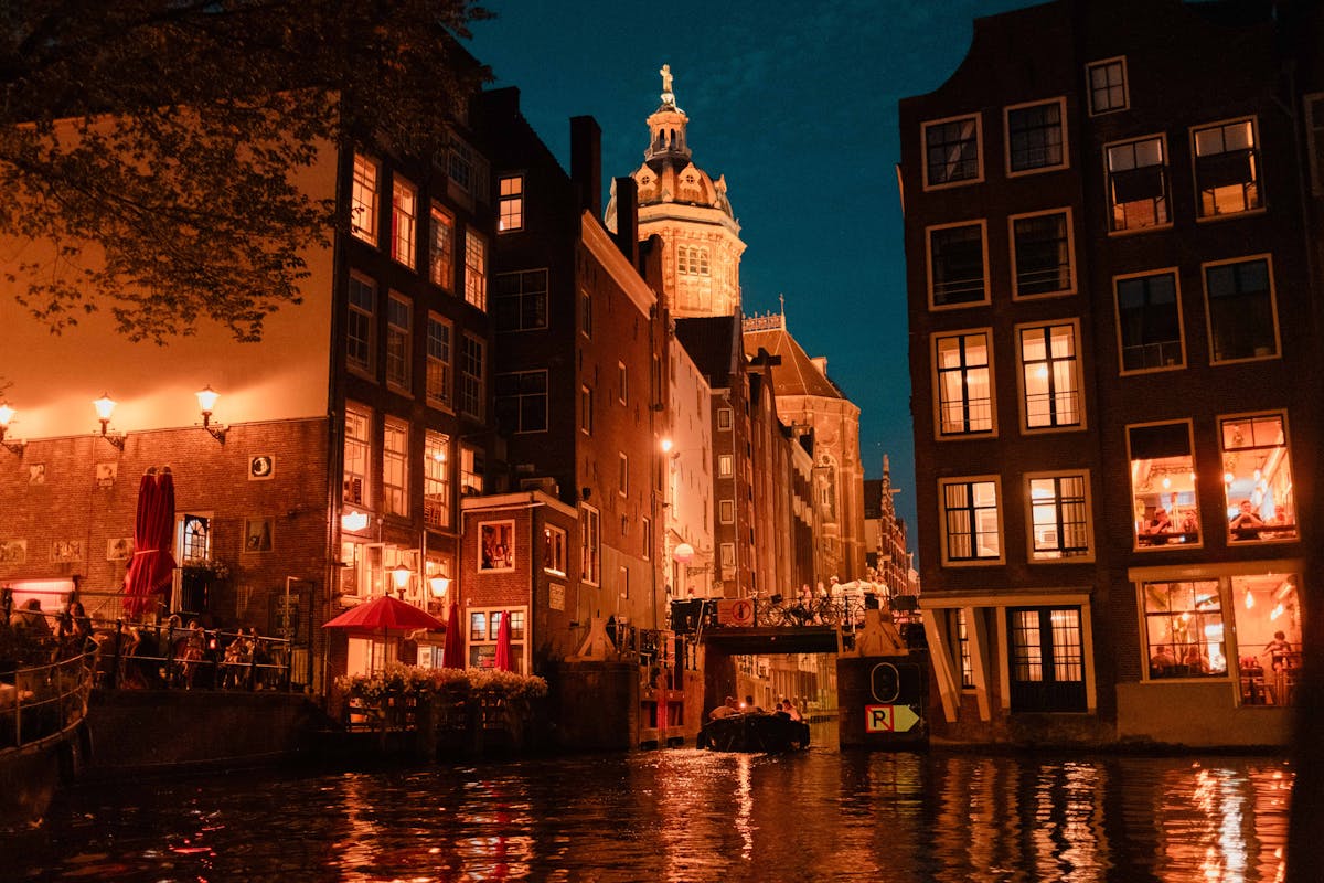 Historic Amsterdam canal architecture illuminated at night