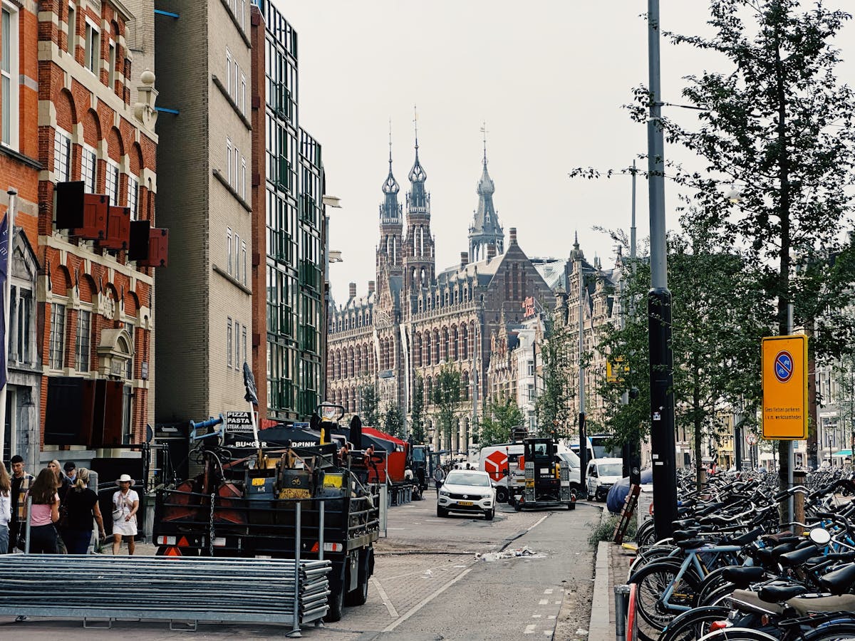 A lively street scene in Amsterdam featuring iconic historical architecture and bustling urban life