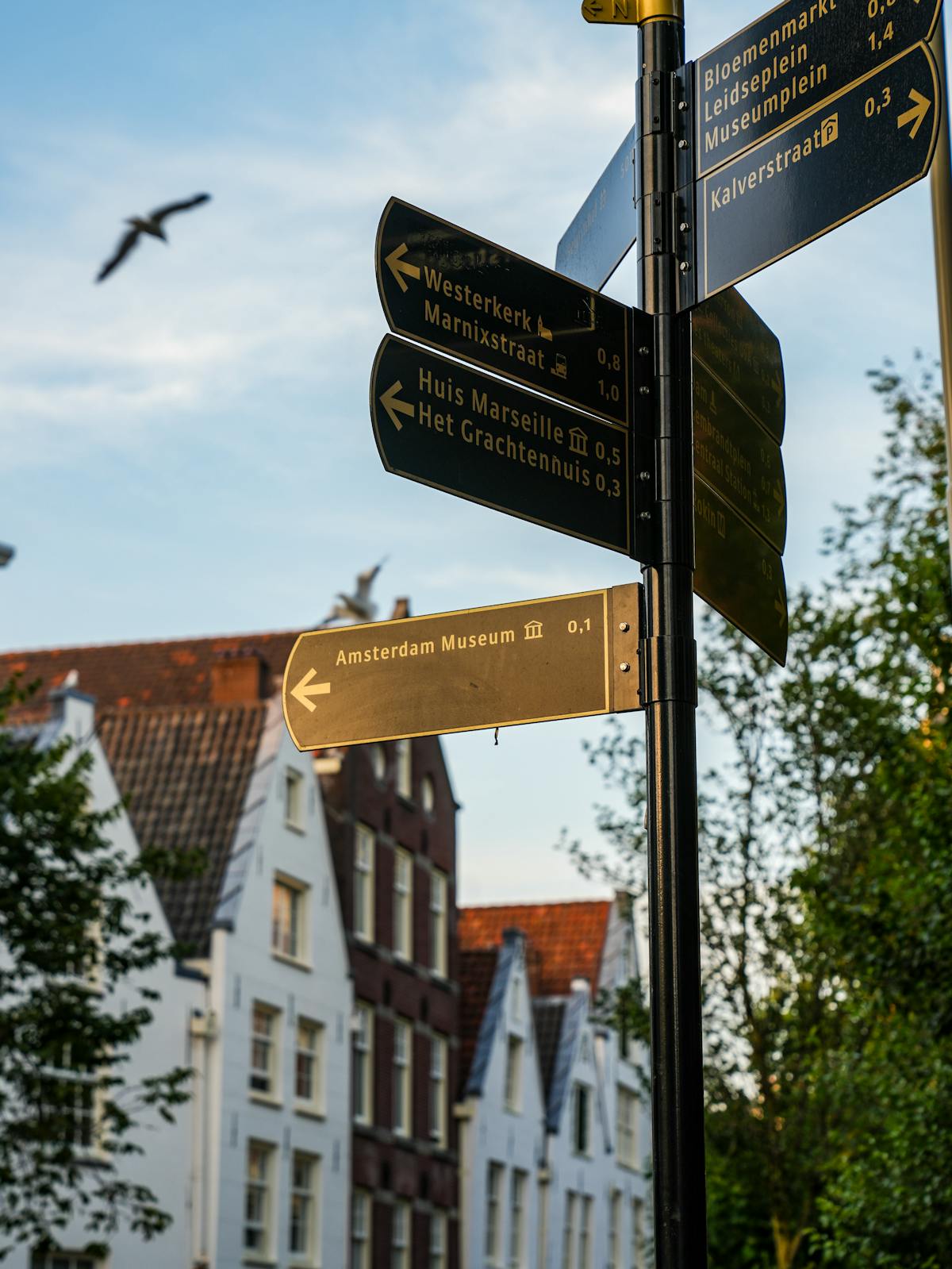 Street signs in Amsterdam pointing to local attractions including museums