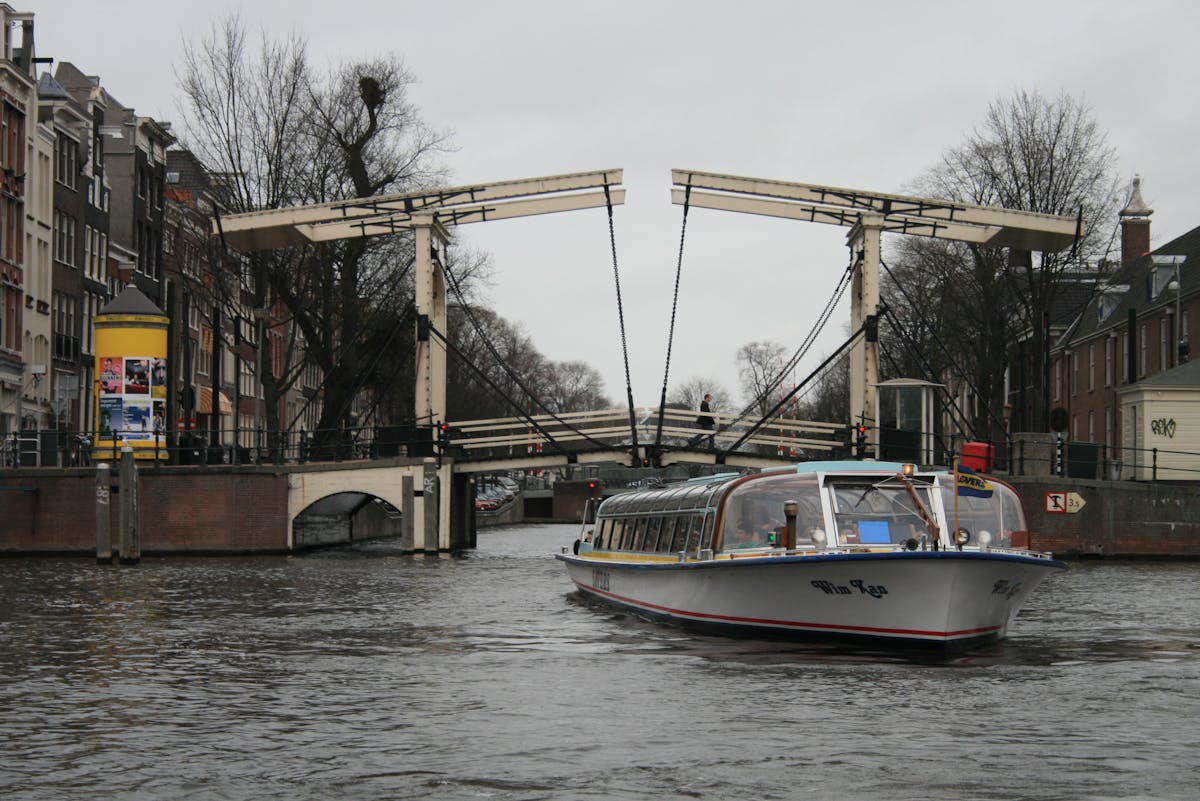 Tour boat on Amsterdam canal with iconic bridge