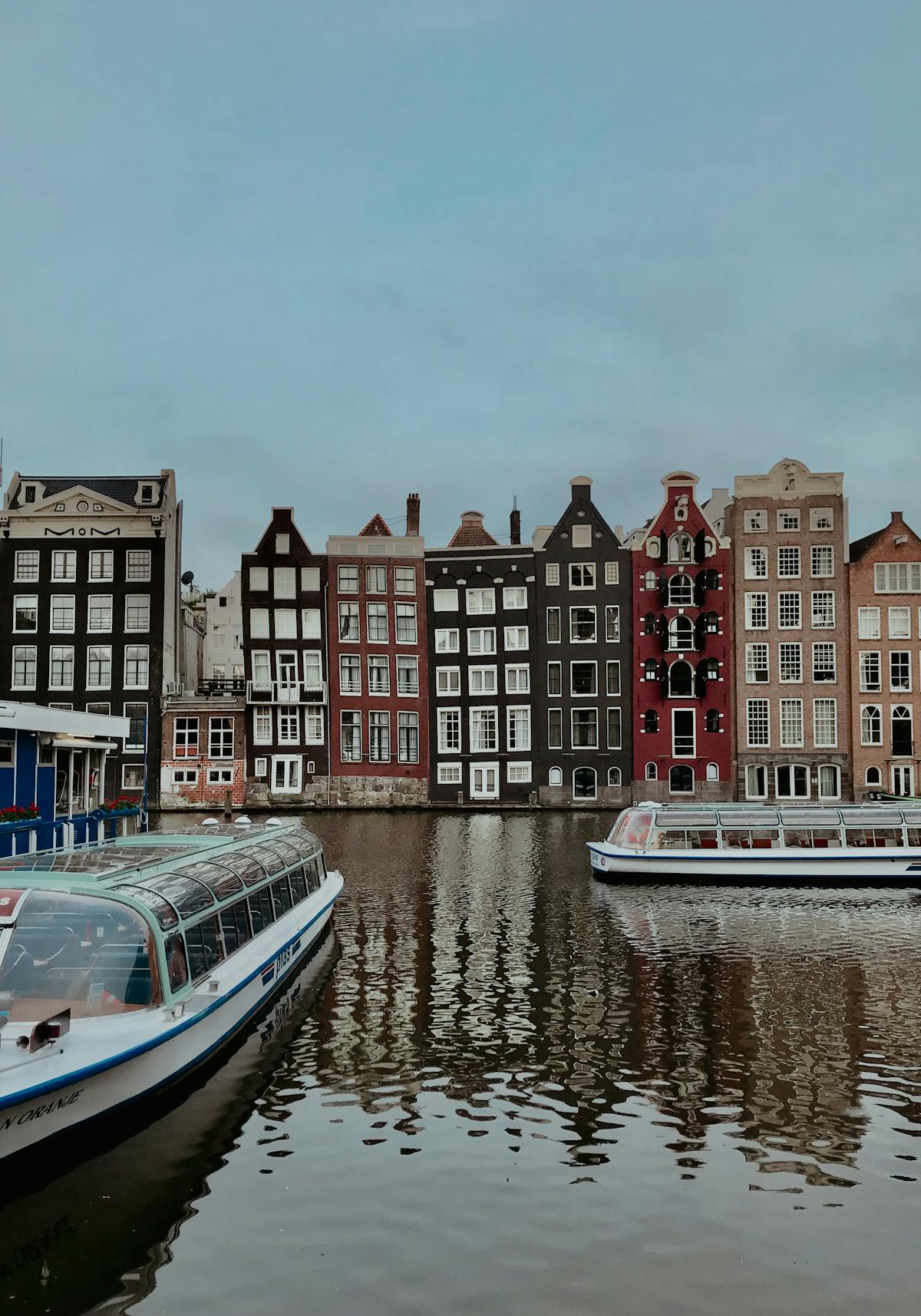 Scenic Amsterdam canal view with traditional Dutch buildings and moored boats