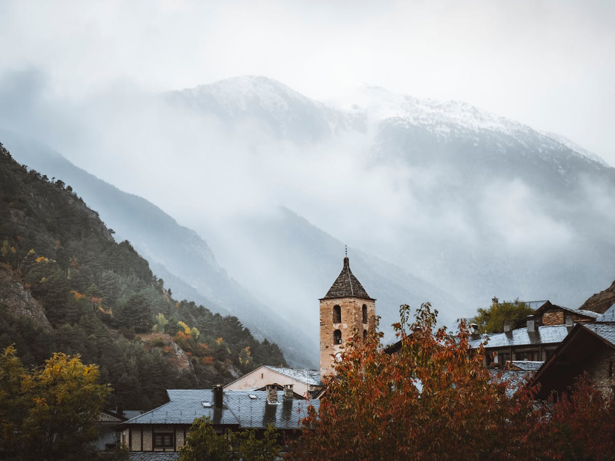 Church tower in Ordino, Andorra with foggy mountains in background
