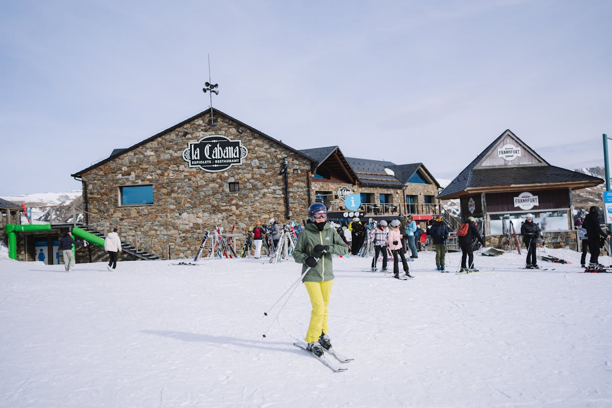 Skiers at a winter resort surrounded by snow-covered slopes in Andorra