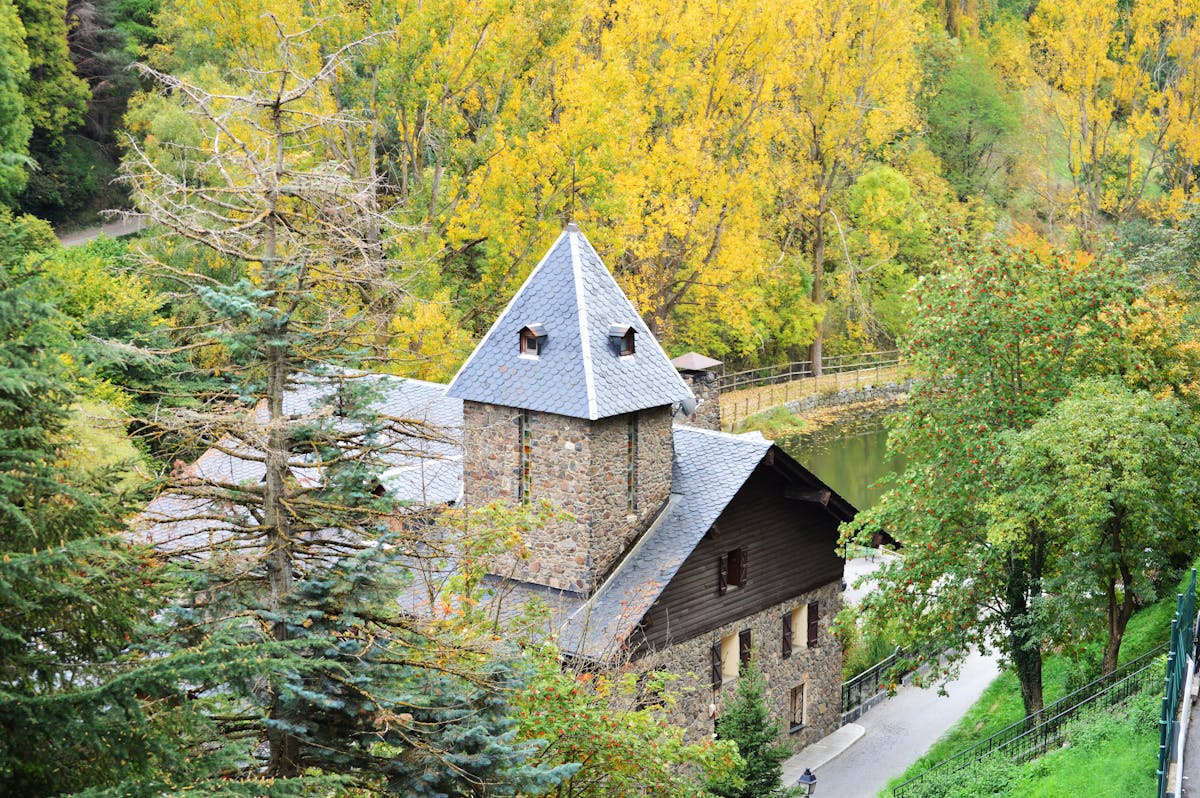Charming stone house among trees next to a river in Andorra la Vella