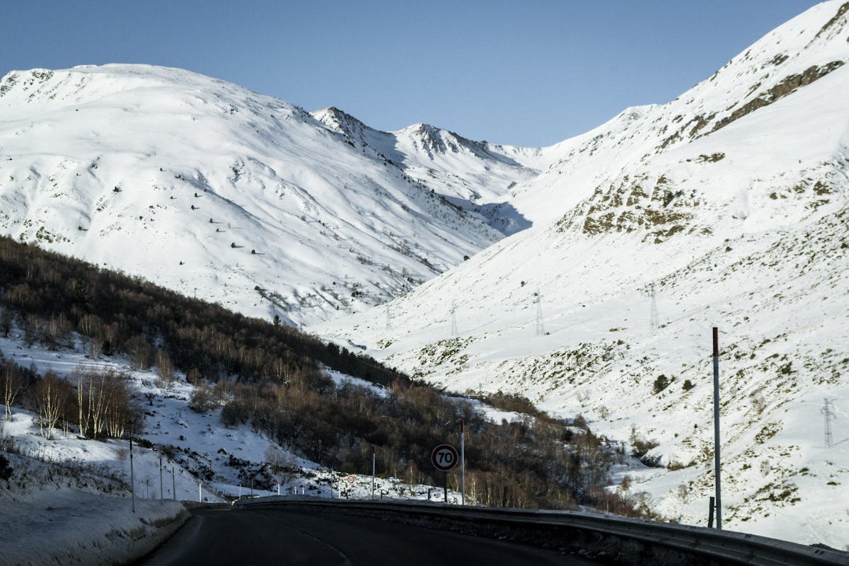 Scenic winter road winding through snow-covered mountains in Andorra