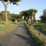 The ancient Appian Way near Rome with original Roman paving stones and tomb ruins along the roadside