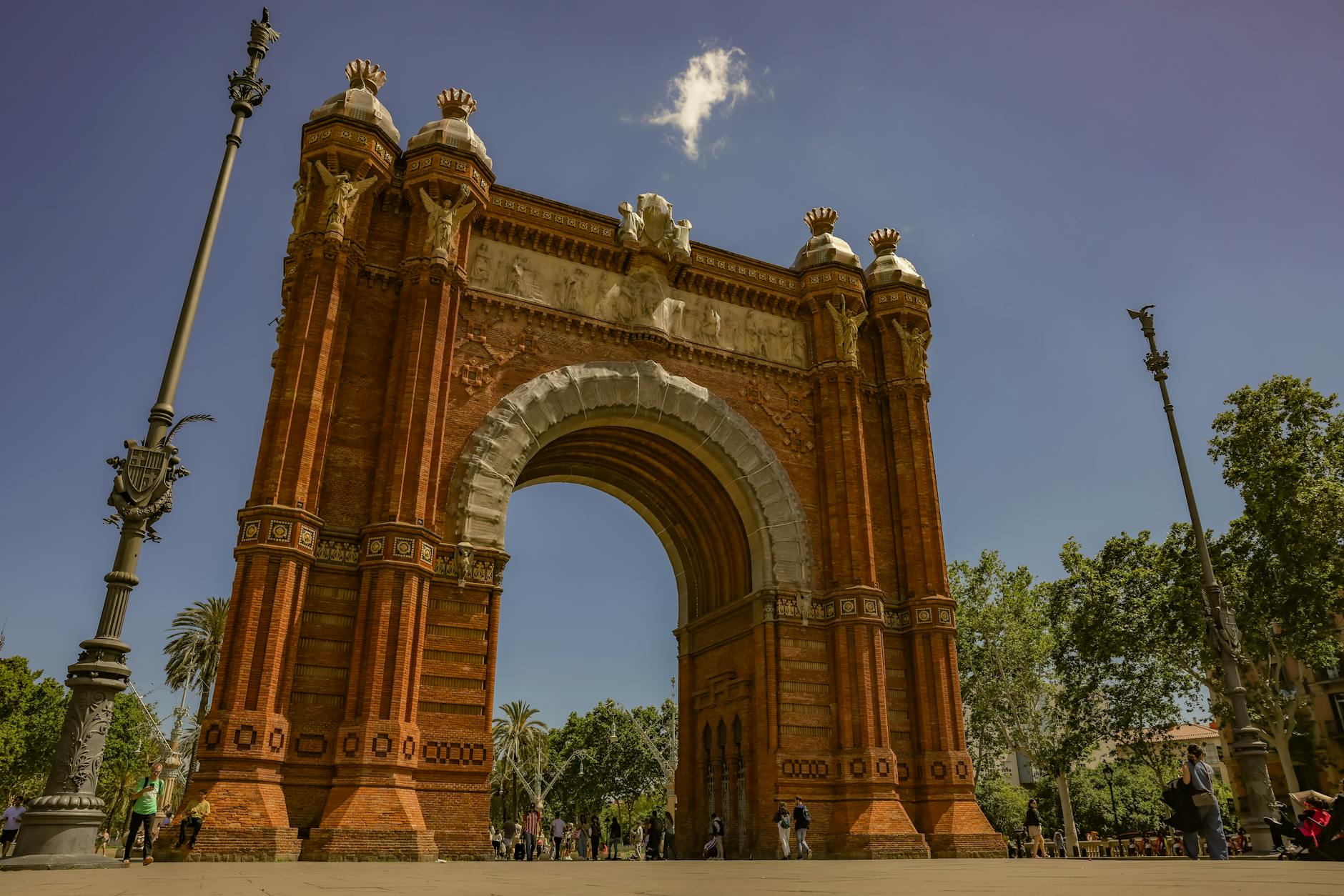 Arc de Triomf in Barcelona on a clear day with travelers and wide promenade