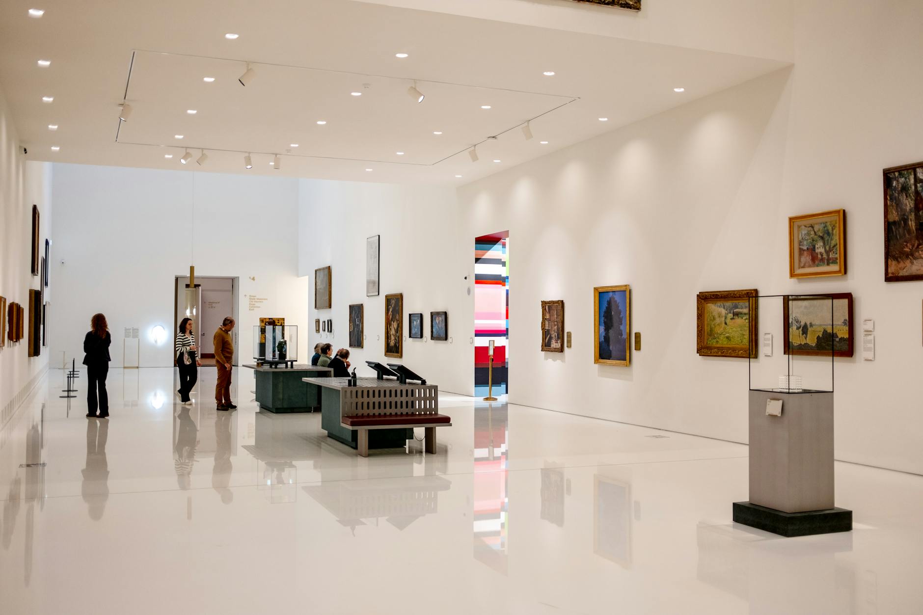 Spacious modern art museum with visitors browsing paintings and exhibits