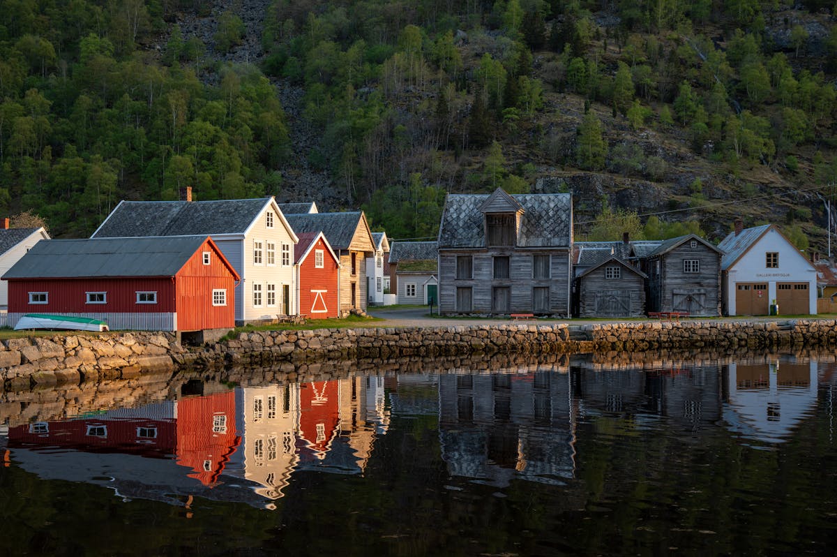 Colorful houses reflecting in calm fjord waters at Aurlandsvangen Norway