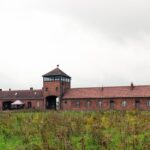 Auschwitz-Birkenau memorial entrance with overcast skies