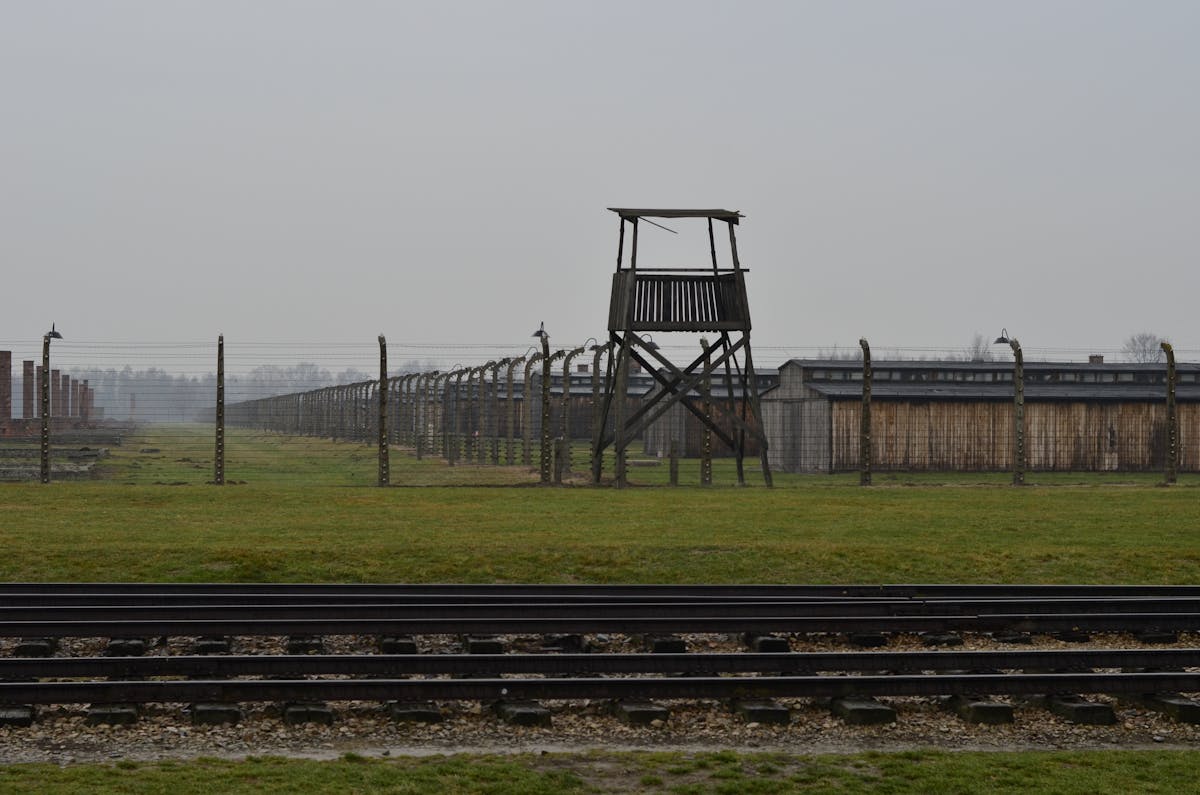 View of Auschwitz concentration camp with railway tracks and watchtower