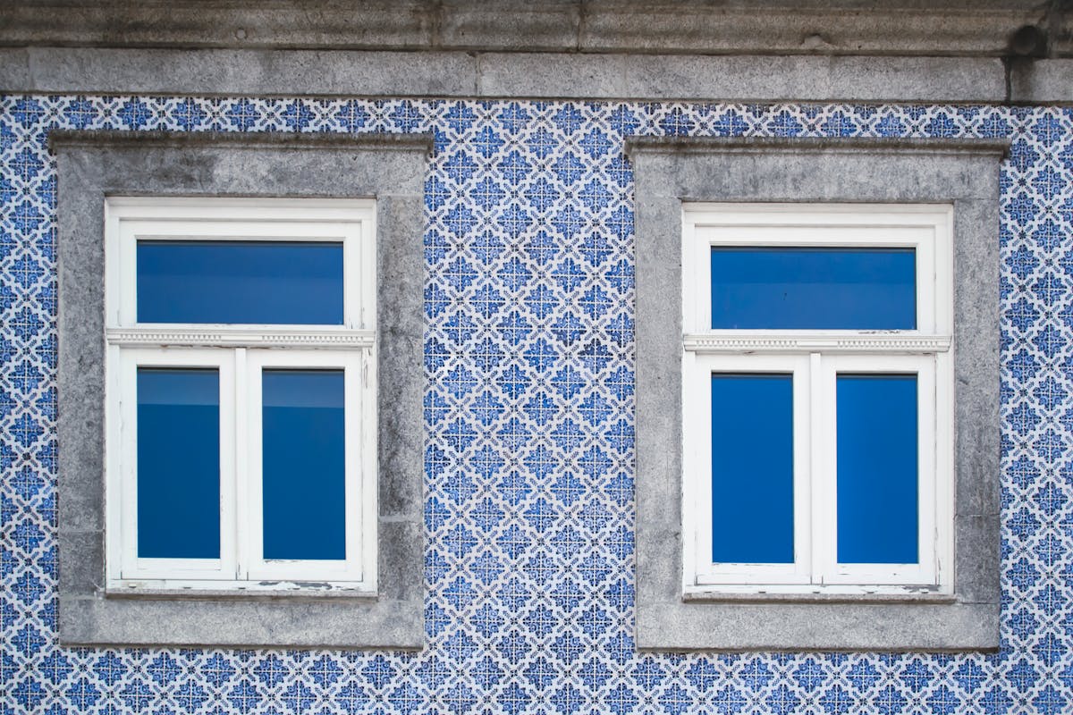 Close-up of a traditional Portuguese facade with blue decorative azulejo tiles and white windows in Porto
