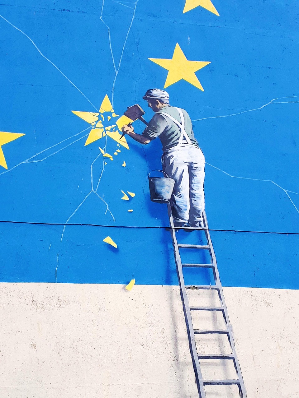 Large graffiti mural with ladder and star on a building wall